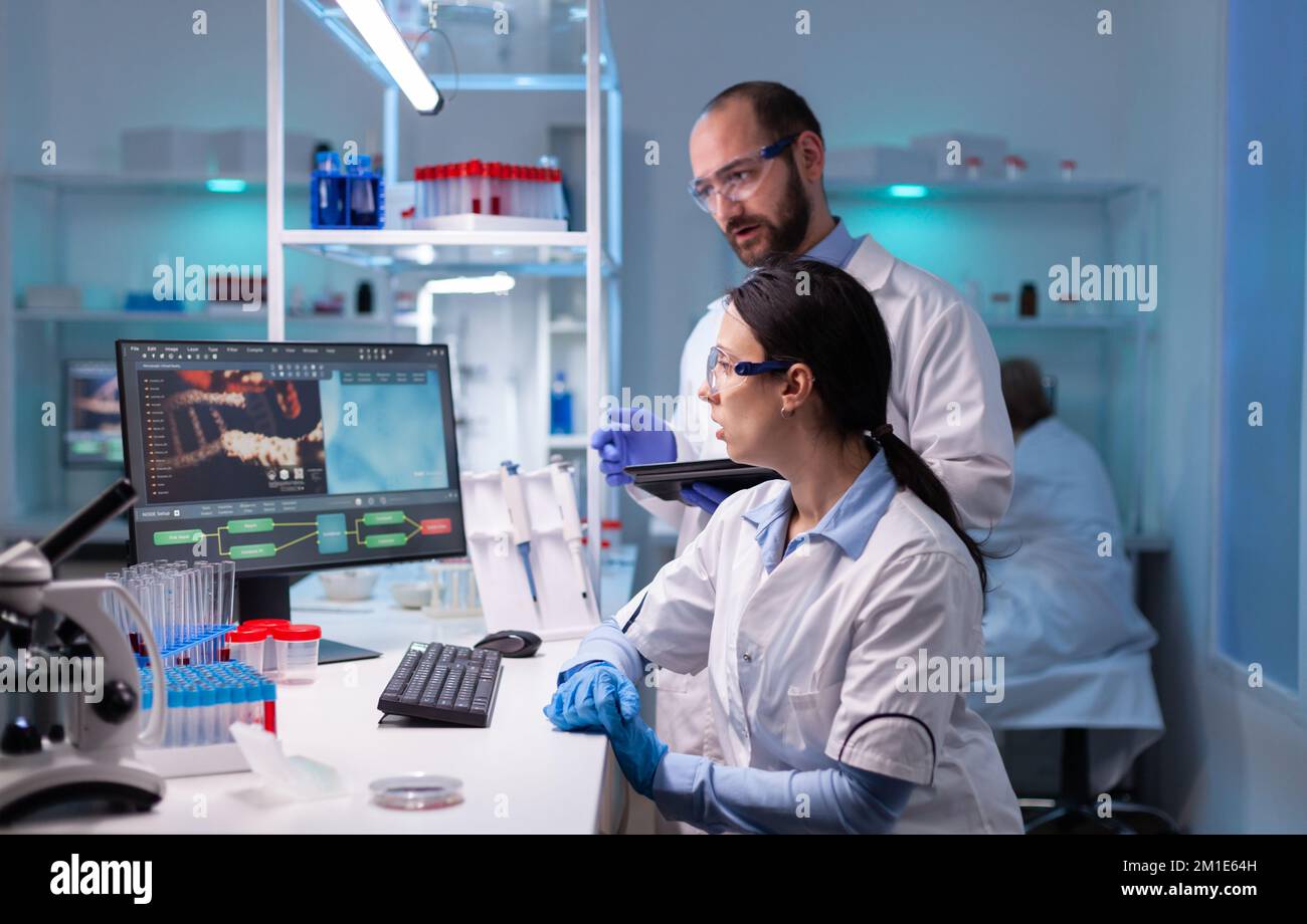 Woman scientist and man doctor studying virus expertise in medicine lab ...