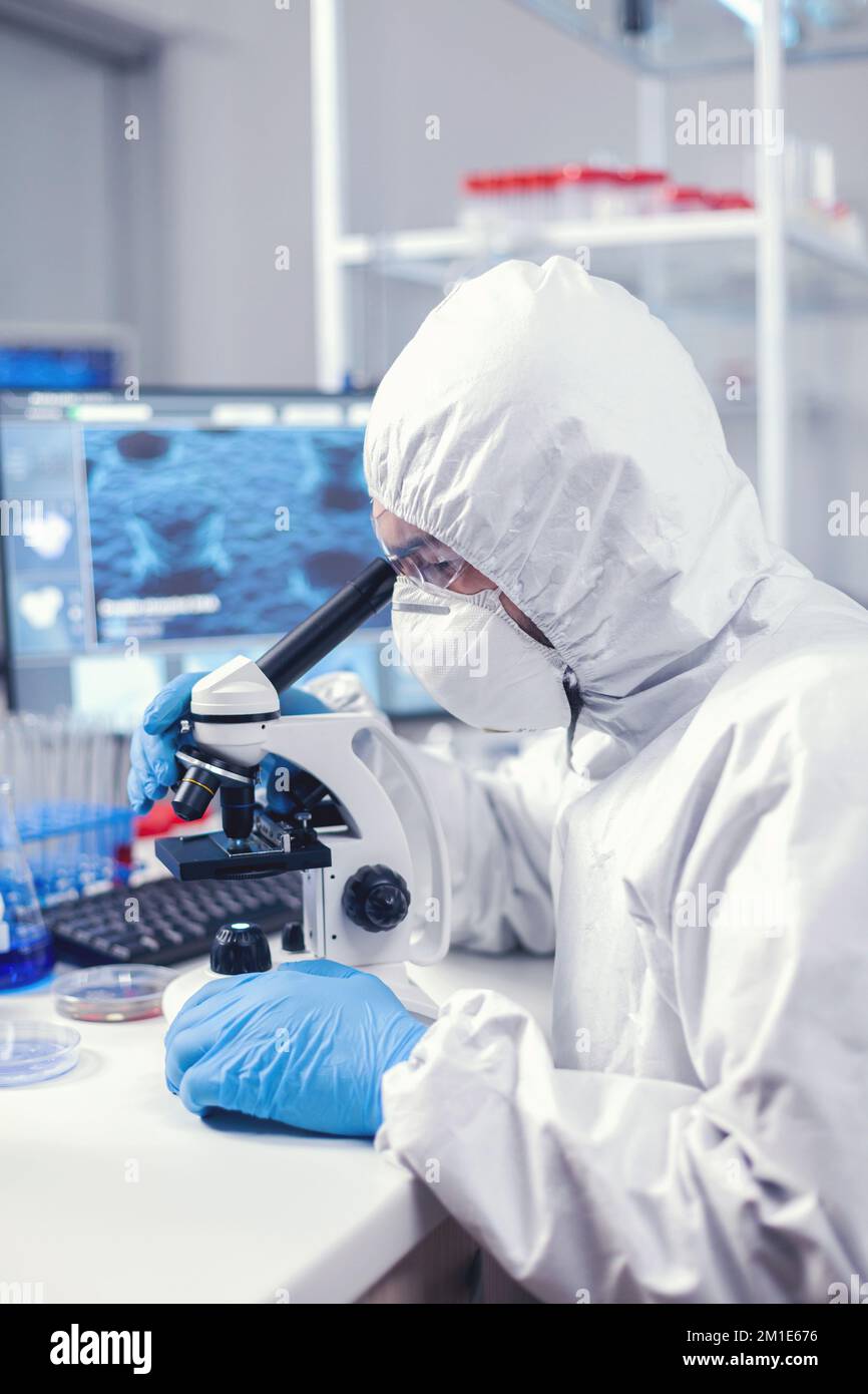 Scientist using modern laboratory equipment dressed in protection ...