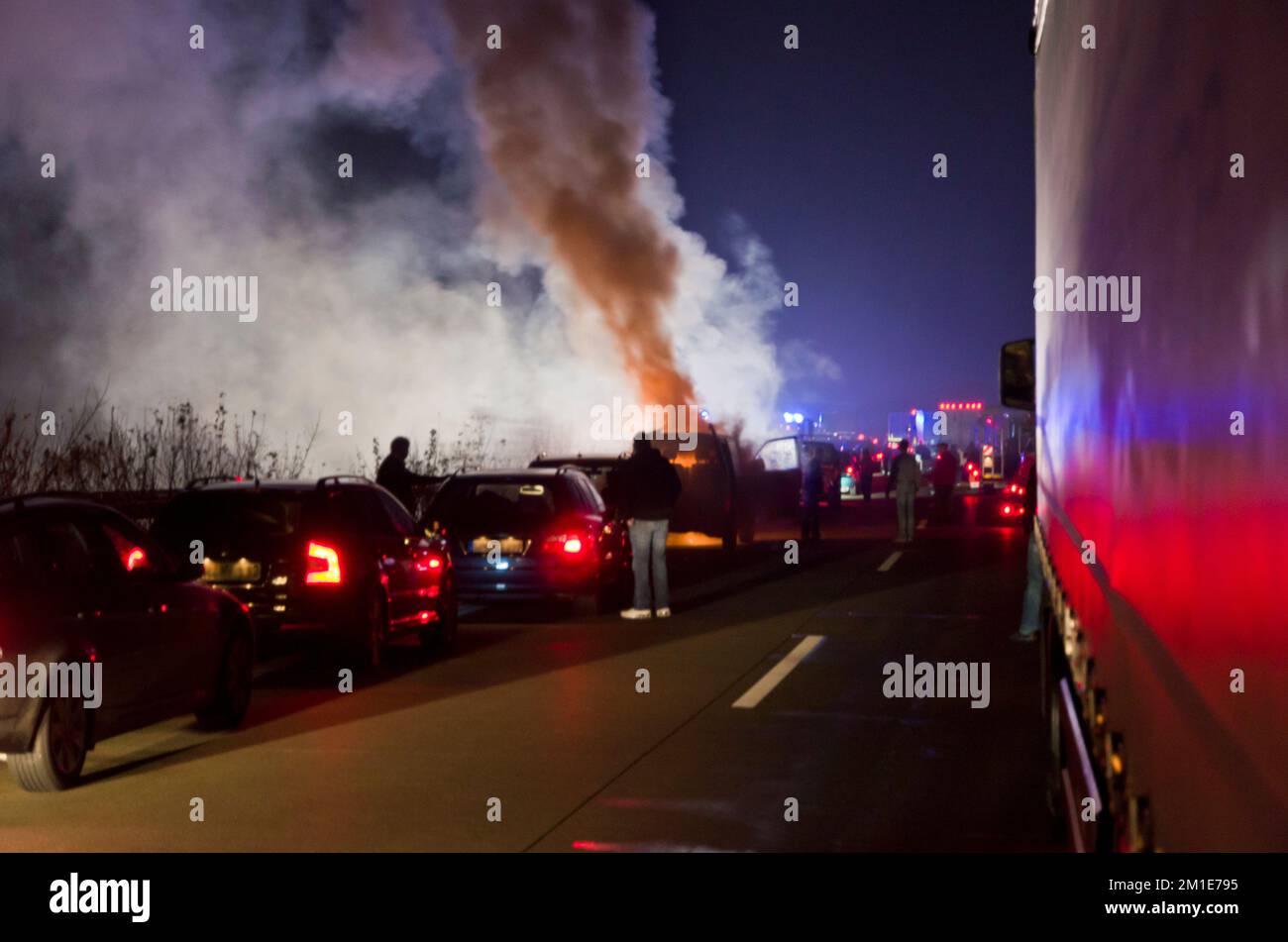 Burning car on a highway after an accident at night Stock Photo - Alamy