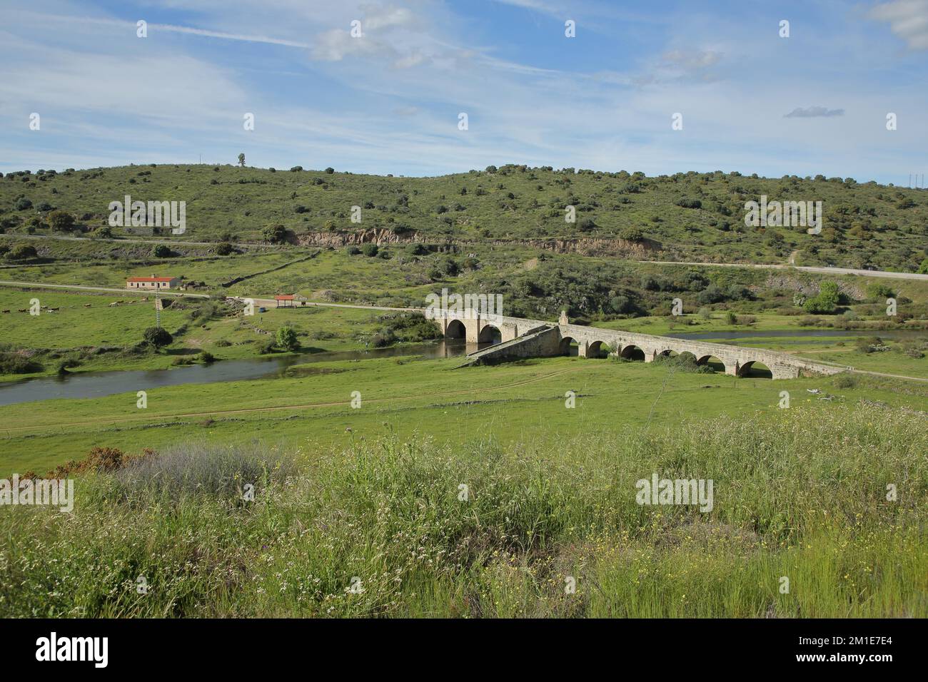 View river Rio Almonte with historic stone arch bridge, Extremadura ...