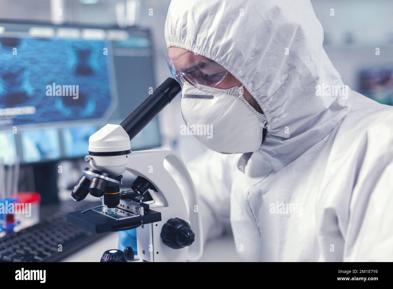 Close up of researcher looking throug microscope in biochemistry ...