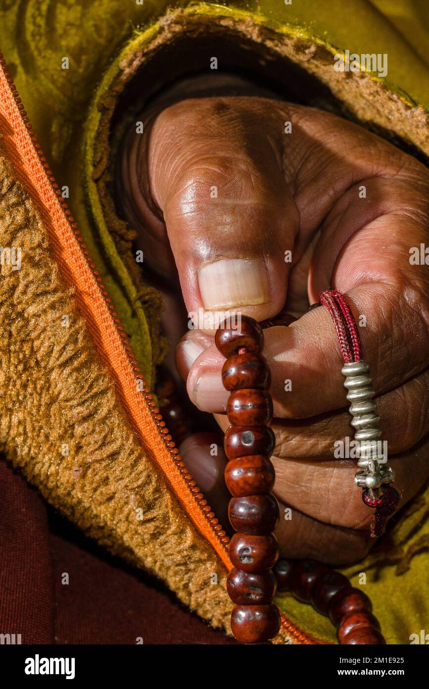 Hand of a monk praying and counting beads at a mala Stock Photo - Alamy