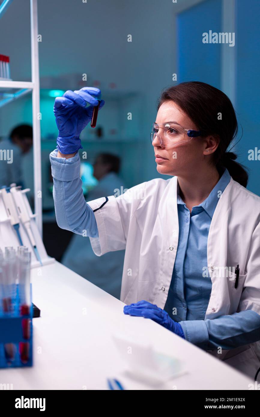 Scientist holding vacutainer blood sample in laboratory healthcare ...