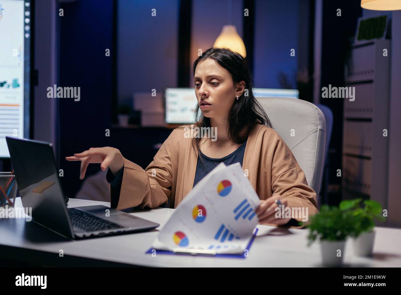 Tired employee reading article to help her finish deadline sitting at ...