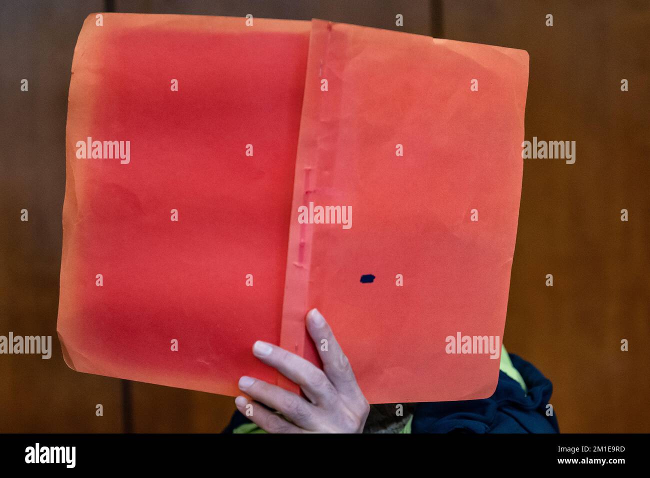 12 December 2022, Lower Saxony, Göttingen: The defendant holds a red ...