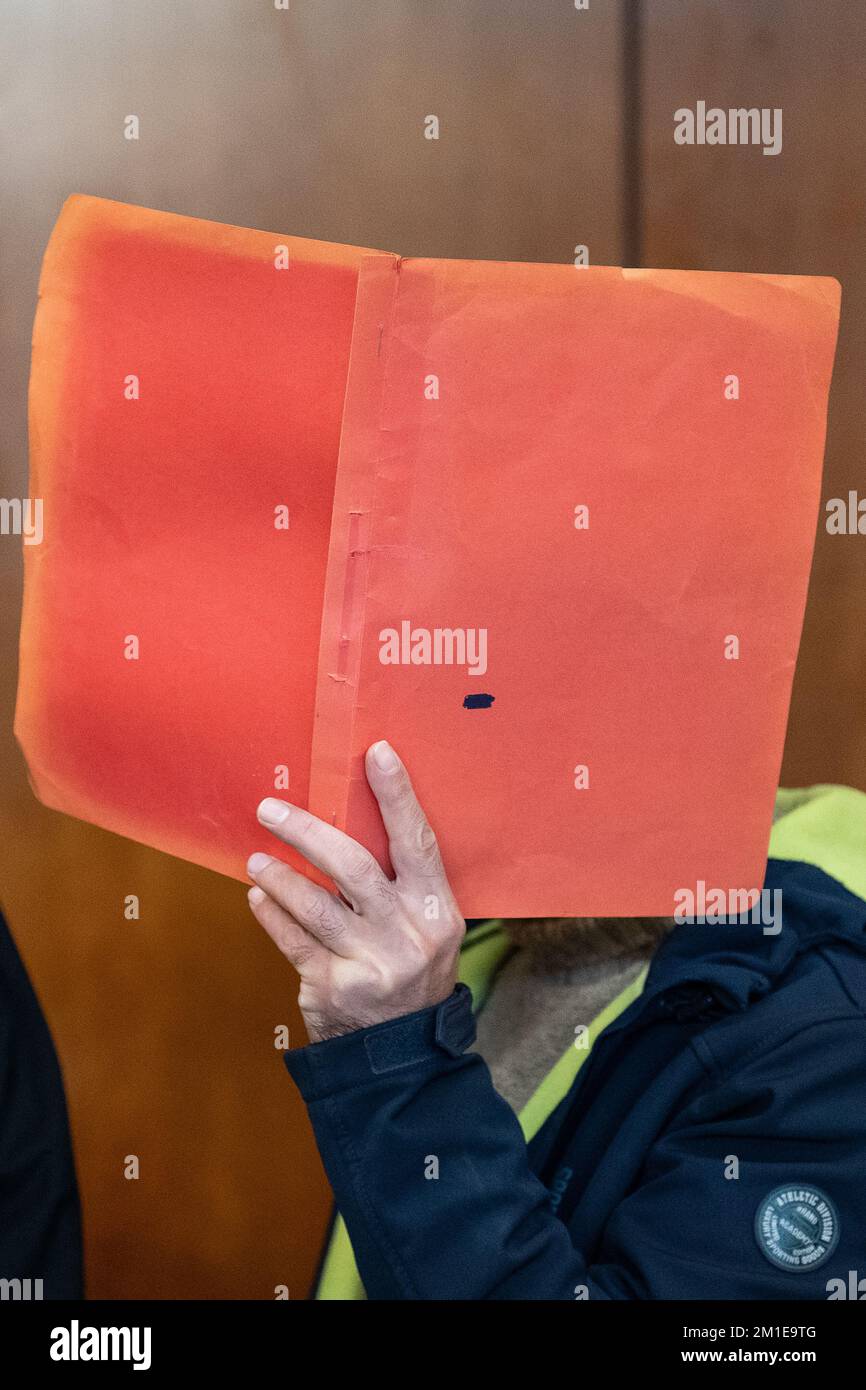 12 December 2022, Lower Saxony, Göttingen: The defendant holds a red ...