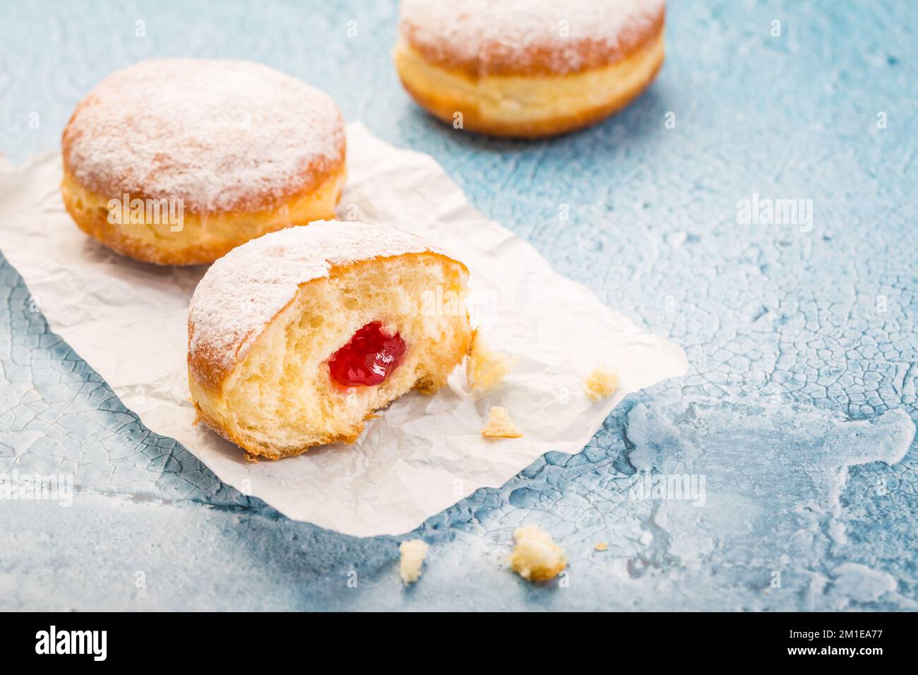 German donuts - berliner filled with strawberry jam with icing sugar ...