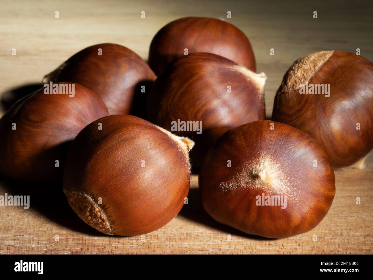 Christmas chestnuts ready to cook resting on a butcher block Stock ...