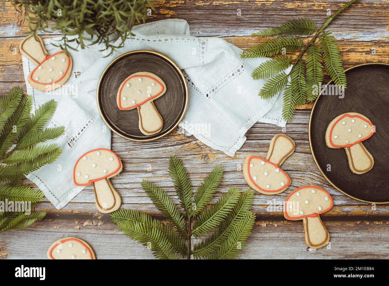 Overhead view of gingerbread mushroom cookies on a wooden table with ...