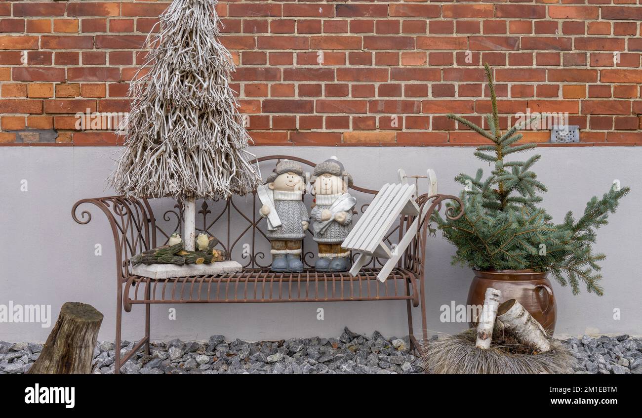 Winter decorations with a Christmas tree, dolls and sleds in front of a ...