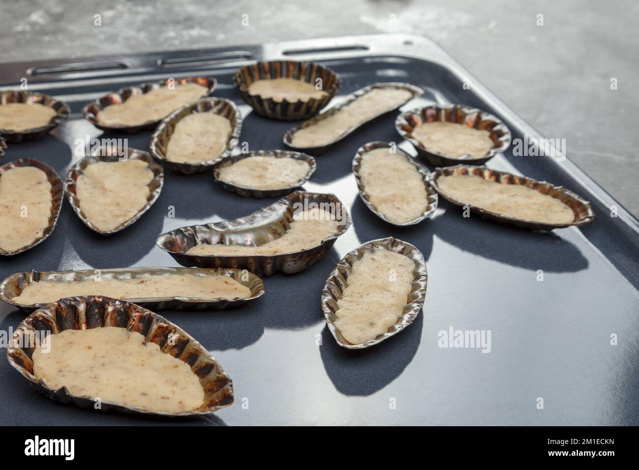 Dough formation. Metal shape. Metal molds with dough lie on the pan for ...