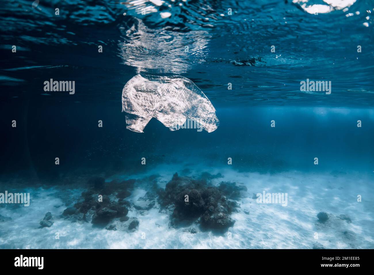 Underwater view in blue ocean with plastic bag and rubbish, ecological ...