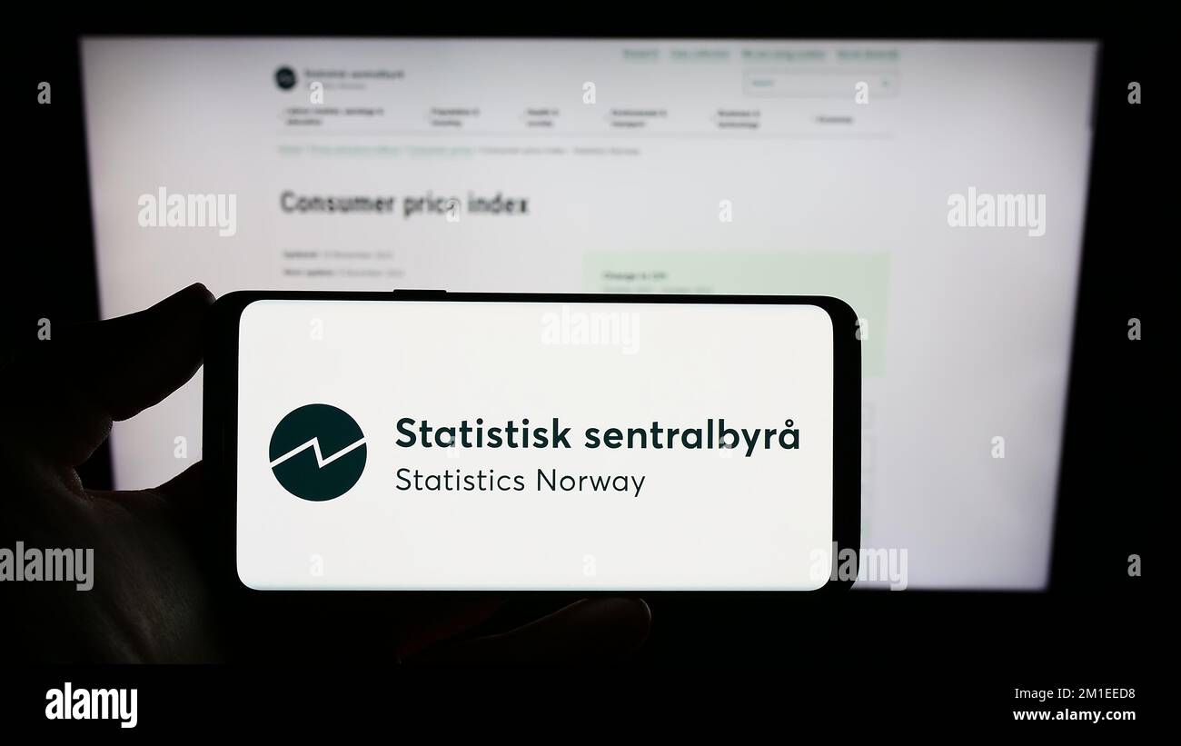Person holding mobile phone with logo of Norwegian agency Statistics ...