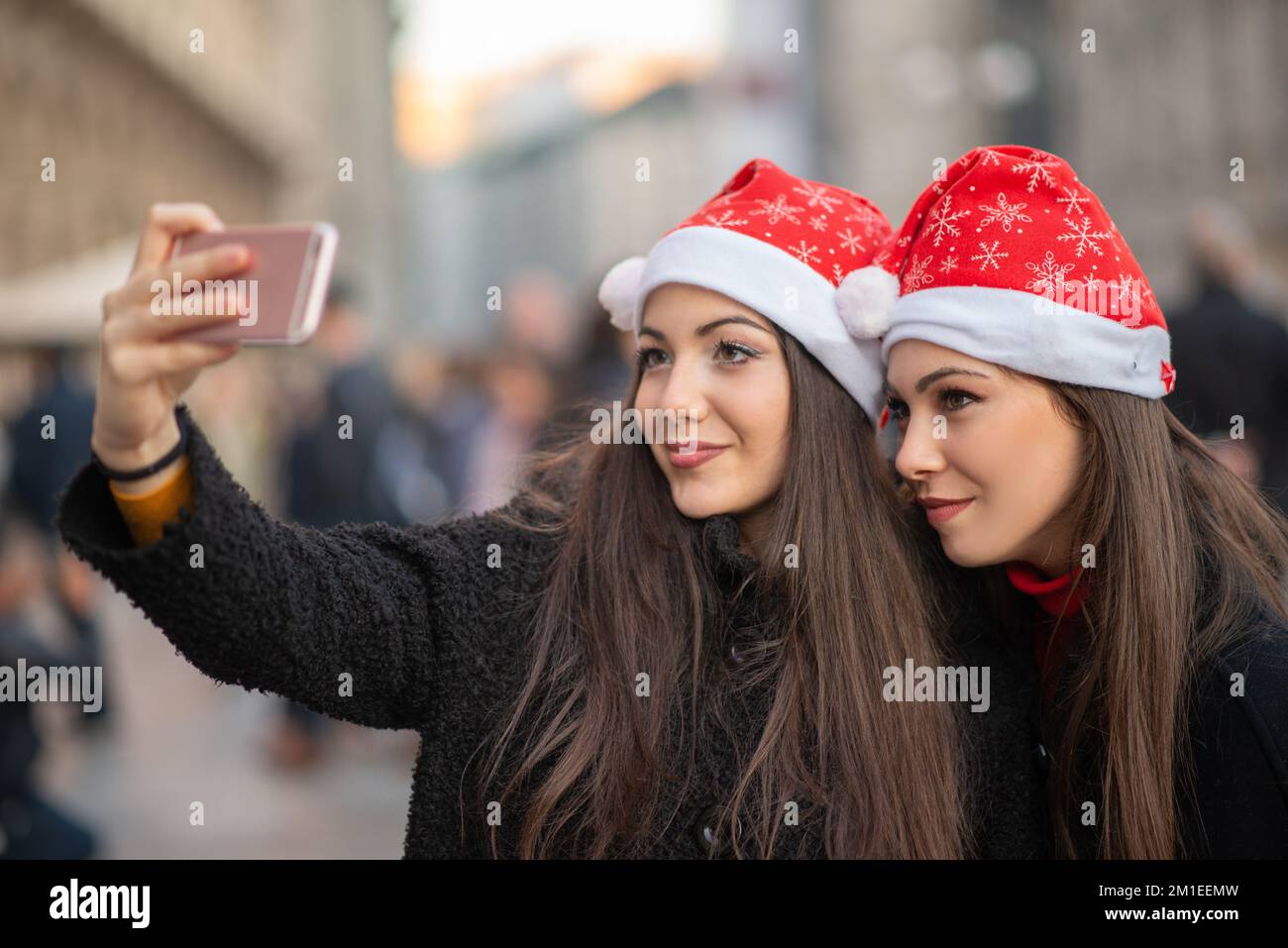 Smiling young women in Christmas hat taking a picture together Stock ...