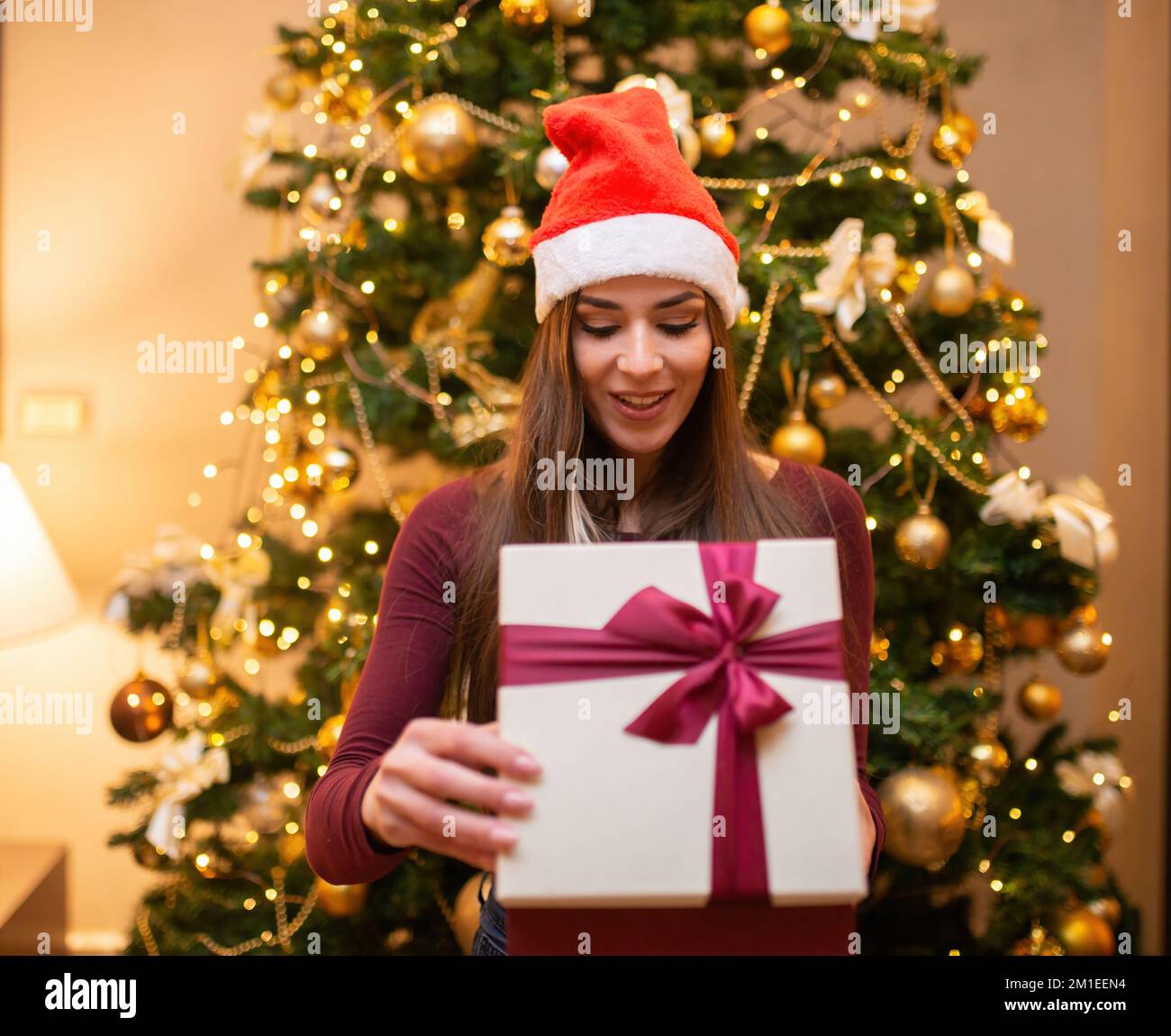 Surprised woman opening christmas present hi-res stock photography and ...