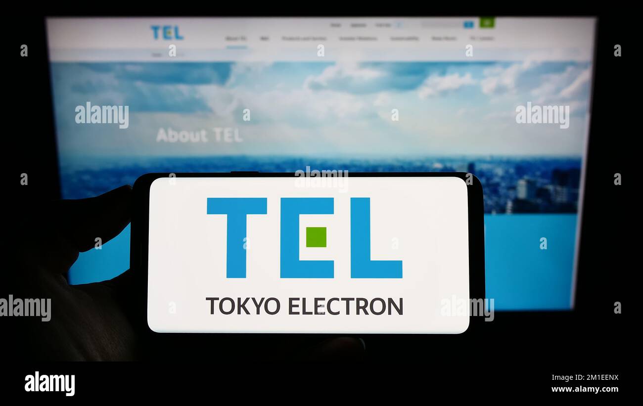 Person holding smartphone with logo of Japanese company Tokyo Electron ...