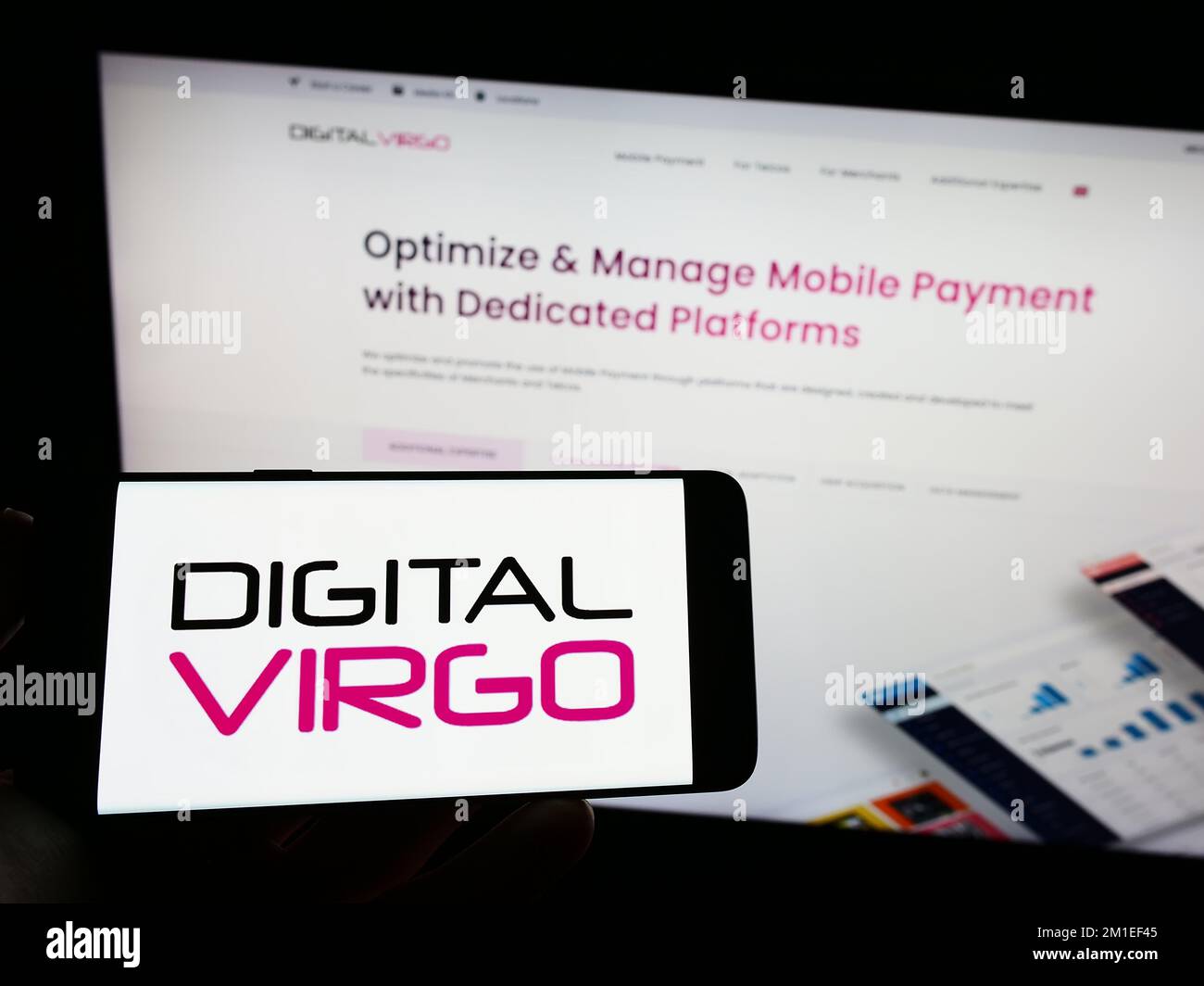 Person holding mobile phone with logo of French payment company Digital Virgo SA on screen in ...