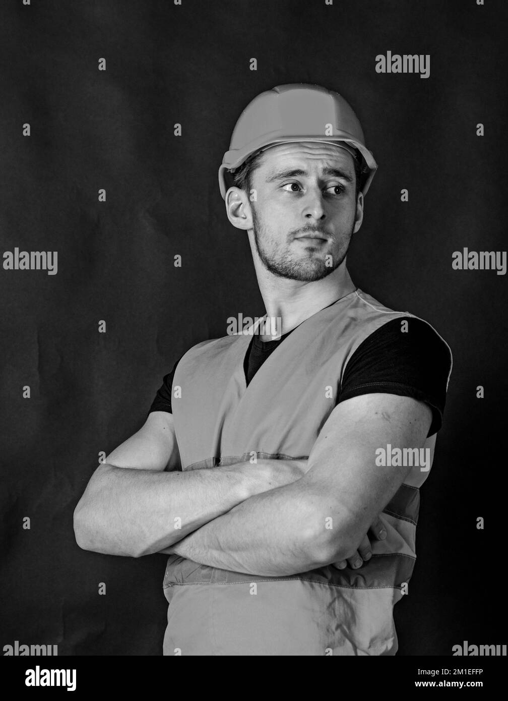 Man in helmet, hard hat hold arms crossed on chest, black background ...