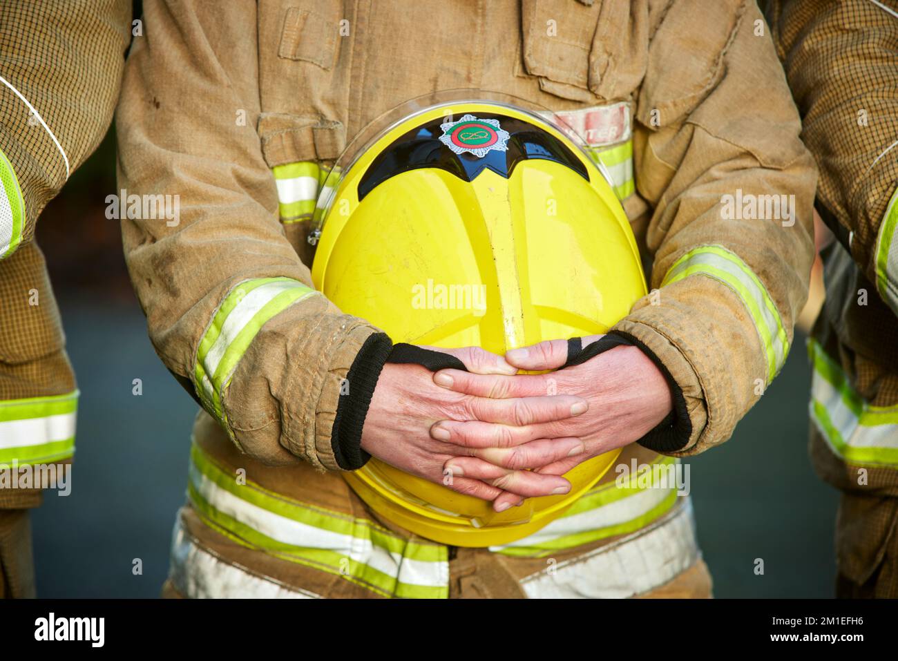 Fireman showing respect holding his helmet Stock Photo - Alamy