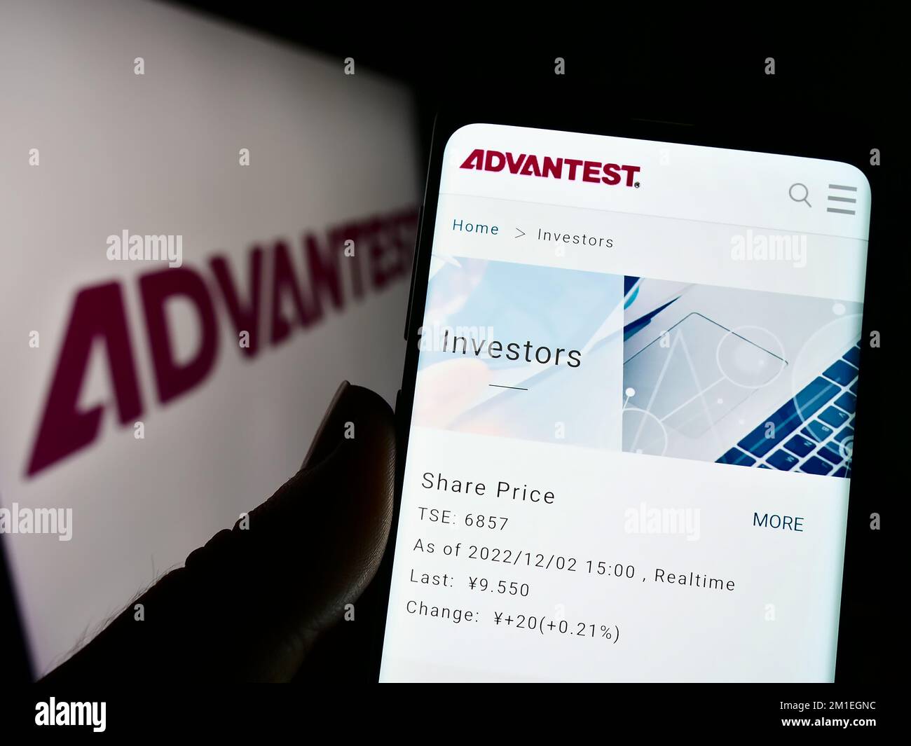 Person holding cellphone with webpage of Japanese company Advantest ...