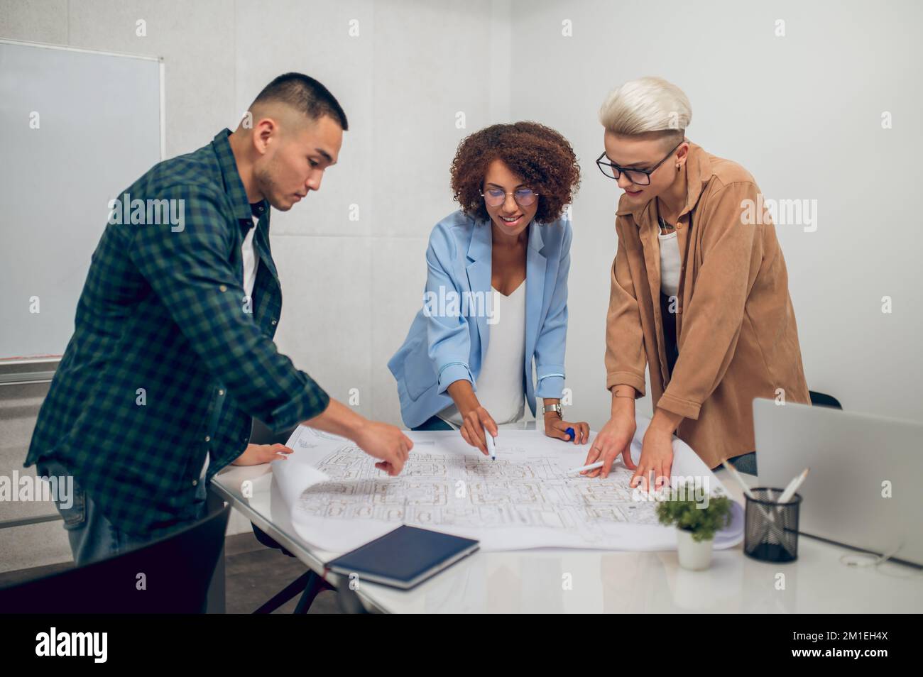 Architectural team working on a technical drawing in the office Stock Photo - Alamy