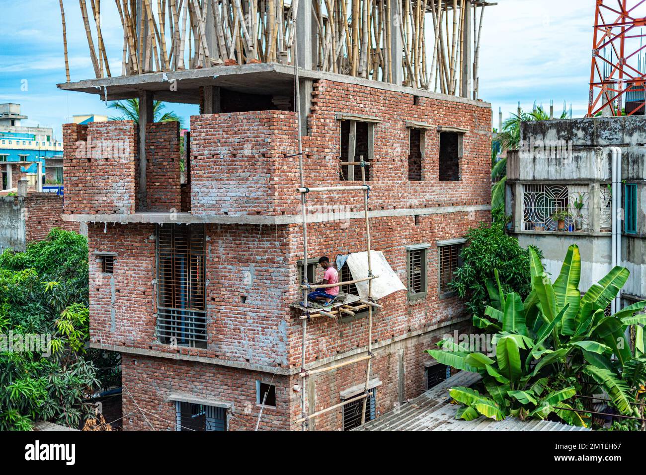 A construction worker doing his job on an incomplete building in a ...