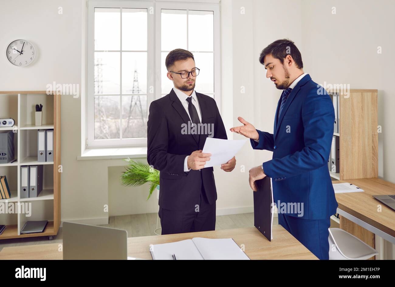 Business colleagues discuss and review paper documents while working in ...