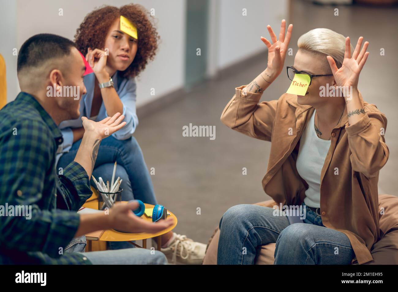 Group of three people involved in playing a guessing gam Stock Photo ...