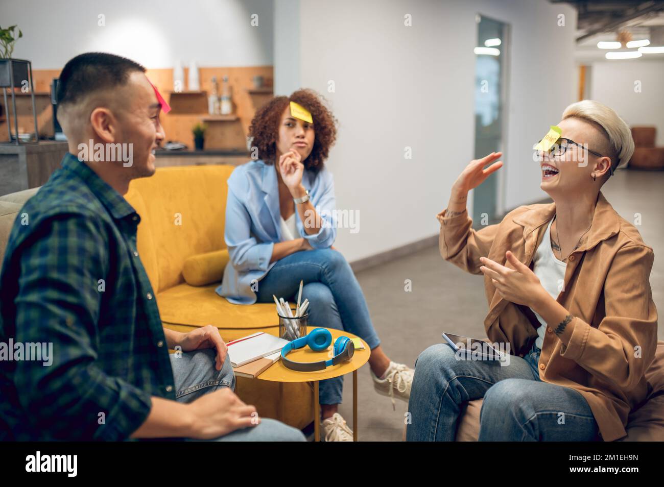 Cheerful company of office workers playing a guessing game Stock Photo ...