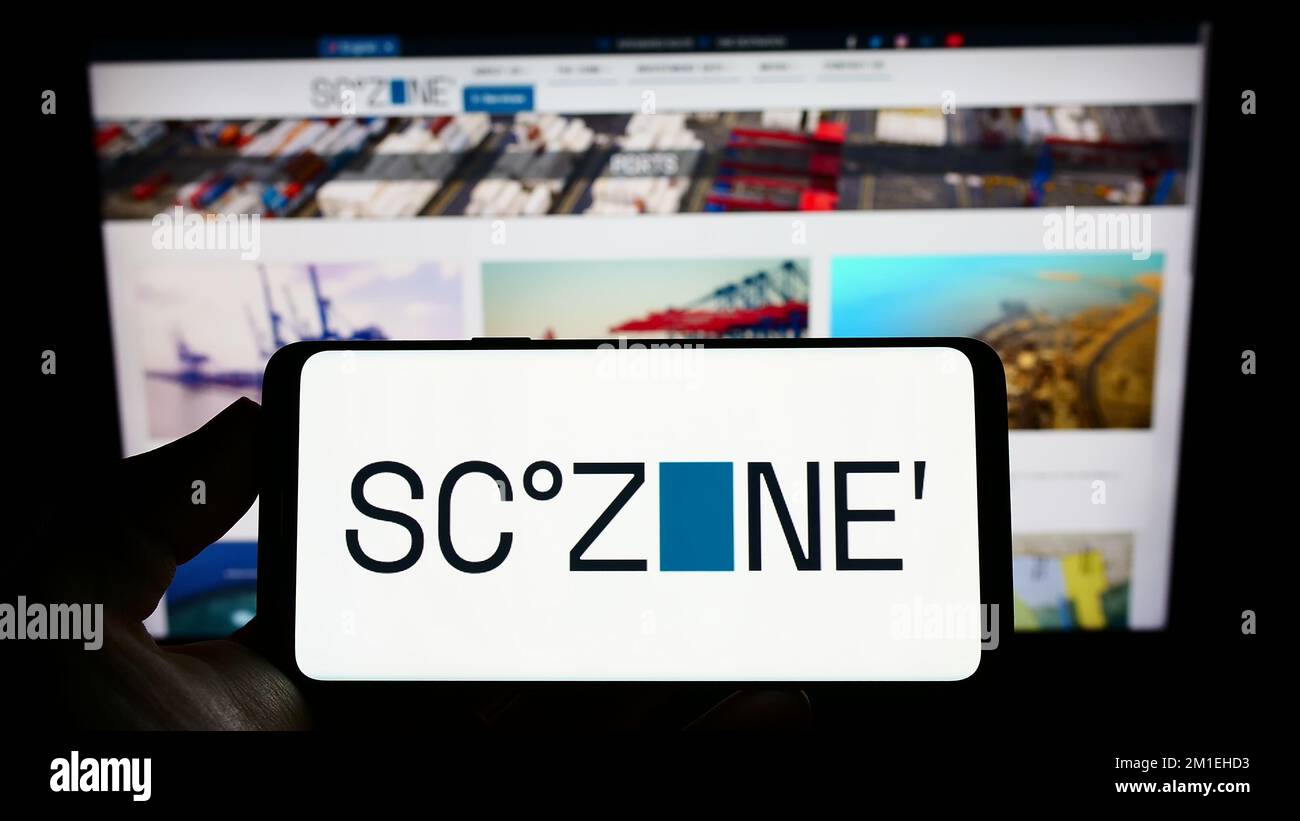 Person holding mobile phone with logo of Egyptian Suez Canal Economic ...