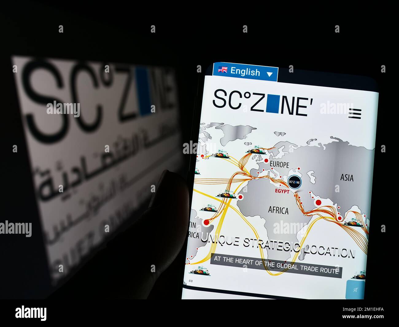 Person holding cellphone with website of Egyptian Suez Canal Economic ...