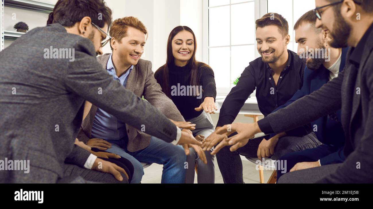 Team of happy, smiling, positive, united business people are huddling ...