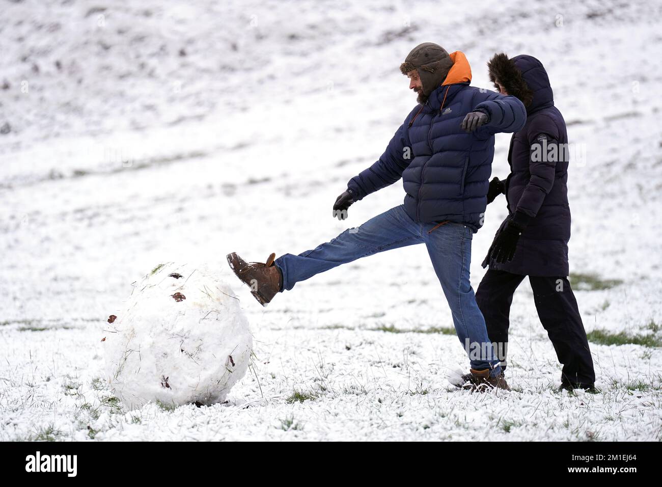 A person kicking a big snowball in Richmond Park in south west London ...