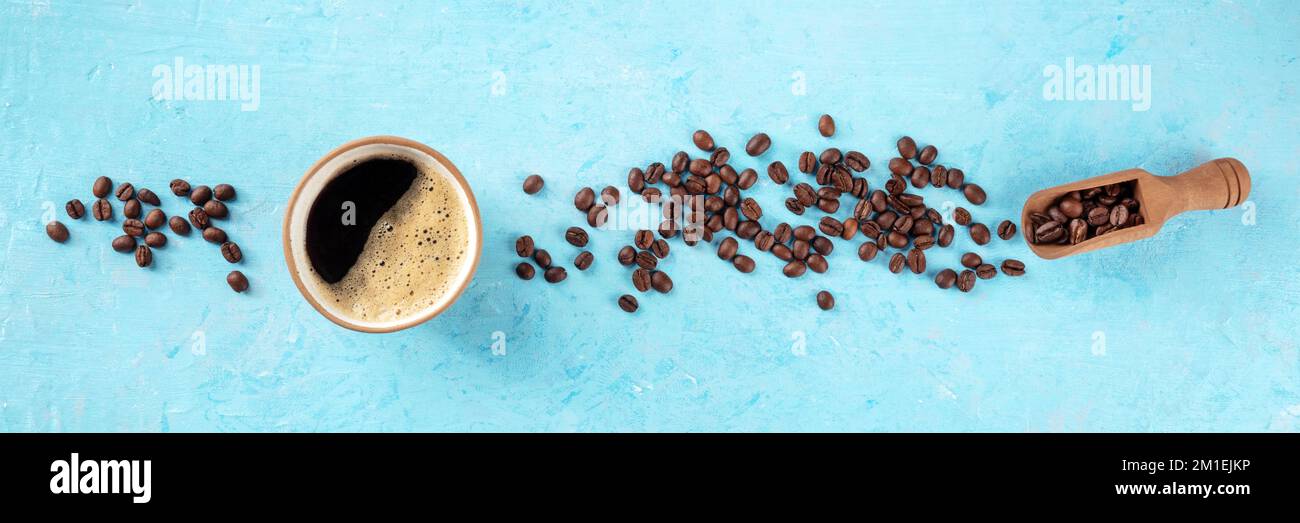 Coffee cup and beans panorama, overhead flat lay shot on a blue ...
