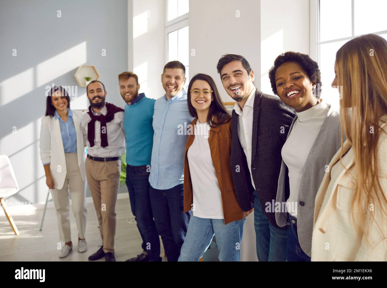Portrait of happy multiracial business colleagues and friends hugging ...