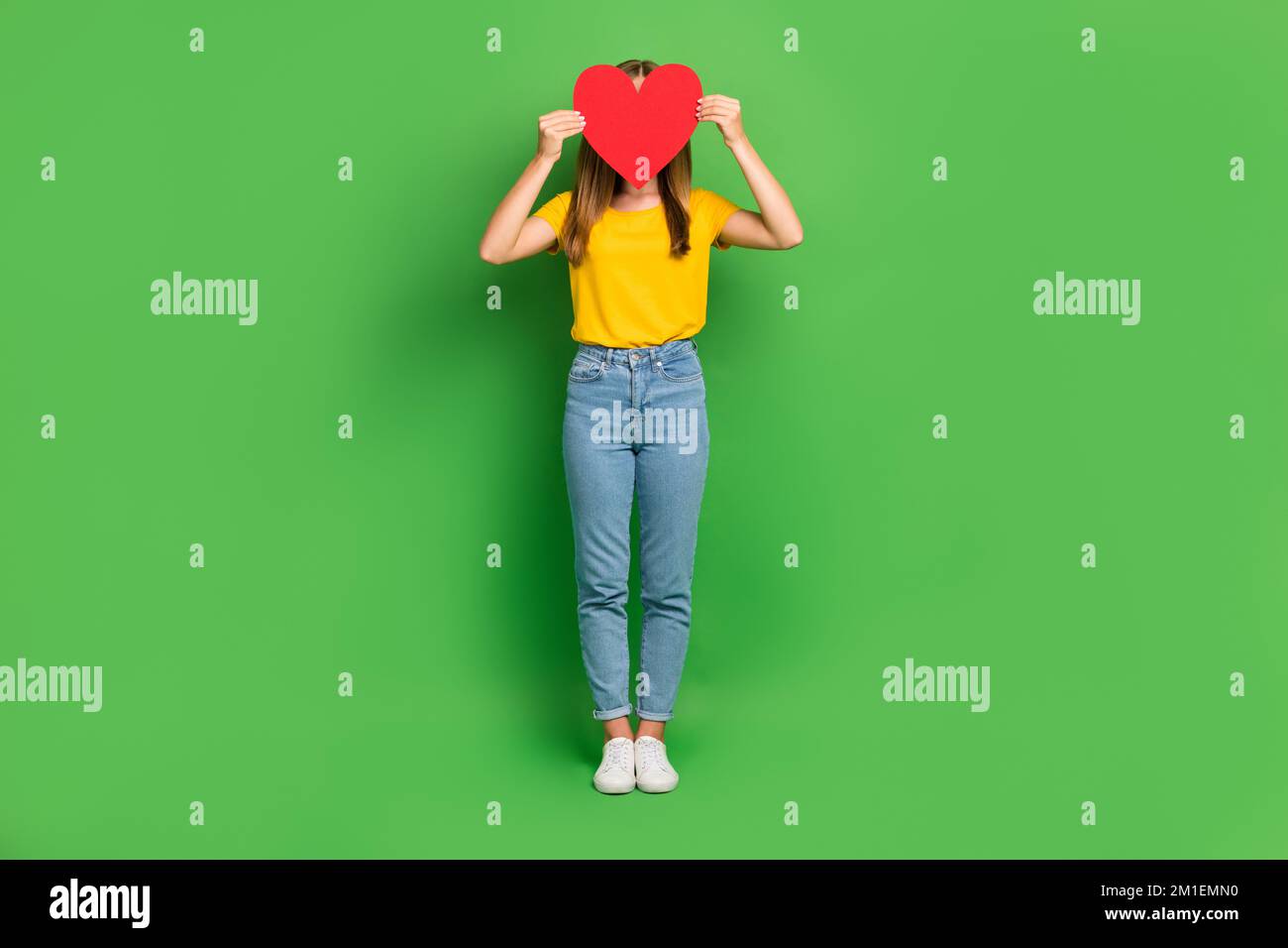 Full body portrait of young girl arms hold paper heart symbol card ...