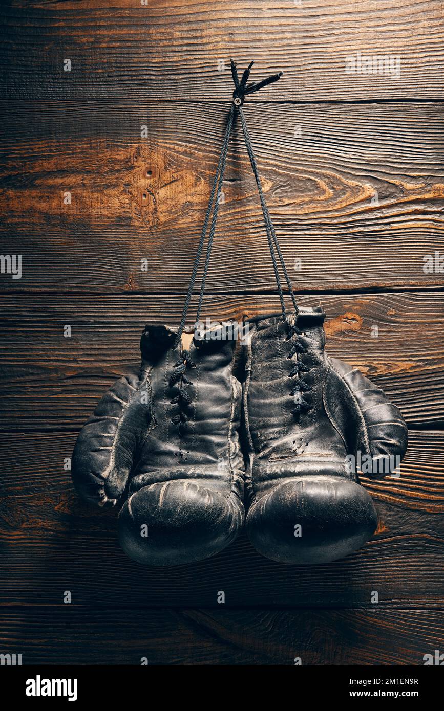 Old boxing gloves hanging on nail on wooden wall. Retirement concept ...