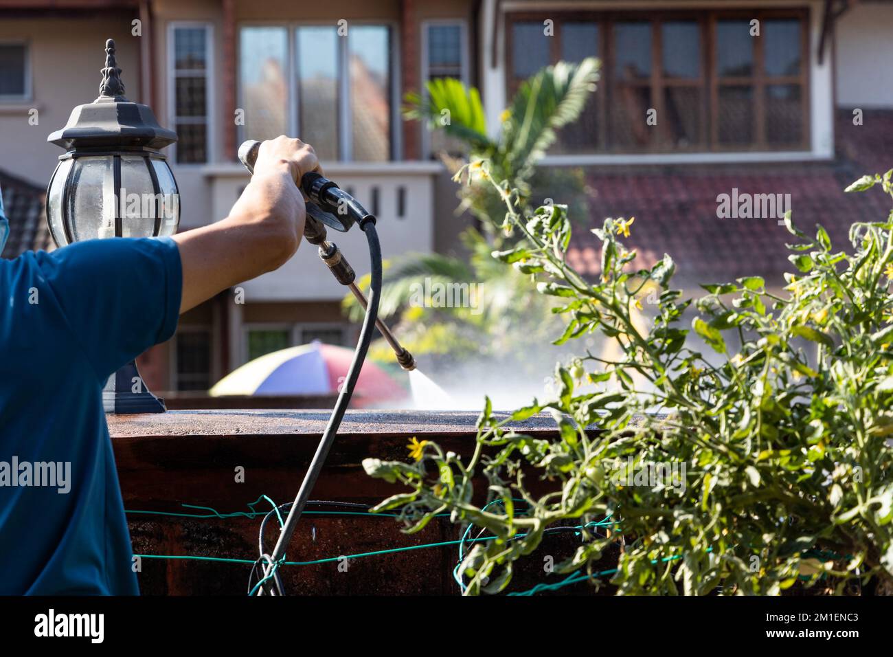 Worker using high pressure water jet spray gun to wash and clean away ...