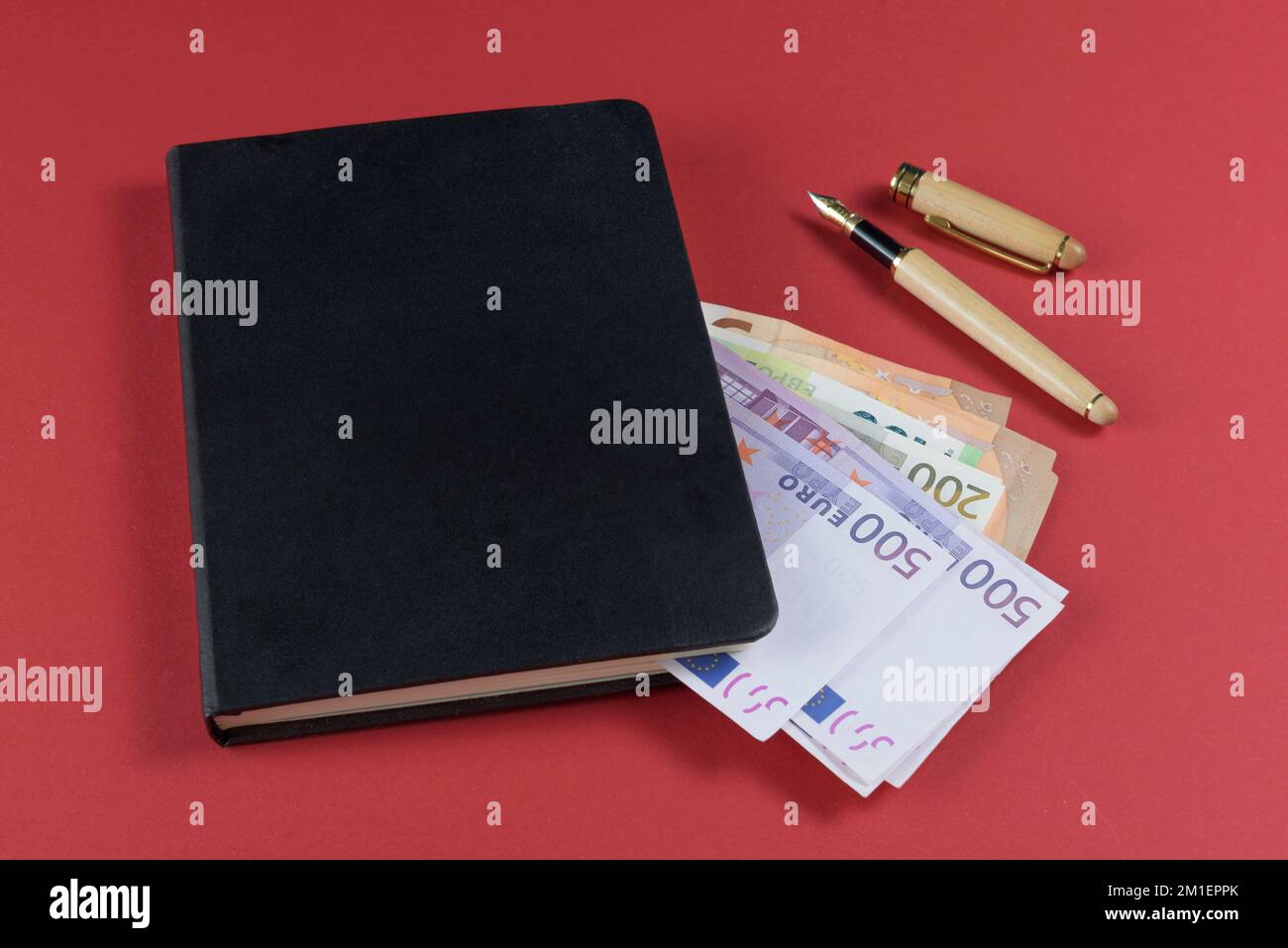 Euro banknotes and fountain pen on red background. Cash counting ...