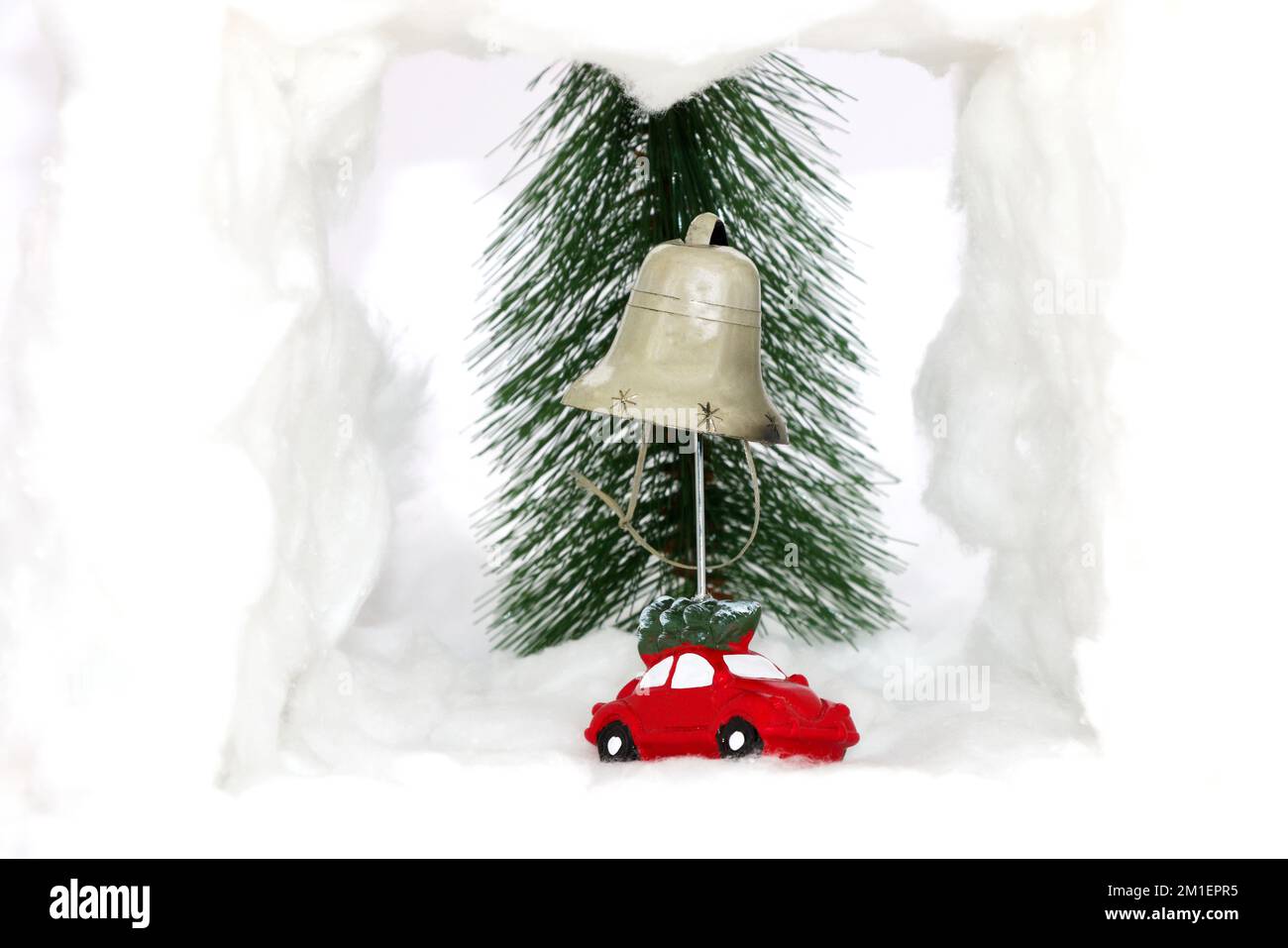 holiday car with bell surrounded by snow, behind the car is a Christmas ...