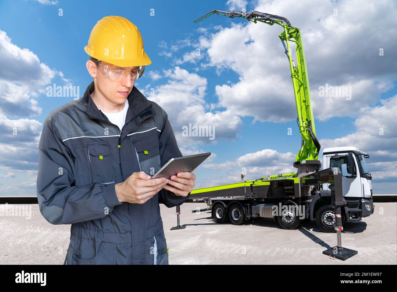 Engineer with digital tablet on a background of truck-mounted concrete ...