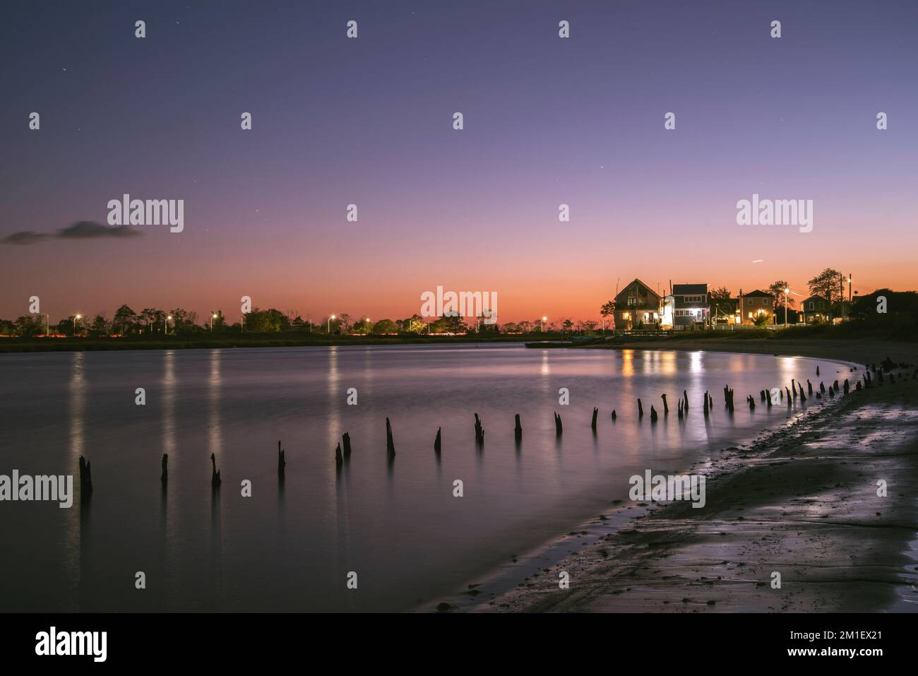 The beautiful view of the smooth sea and illuminated shoreline at ...