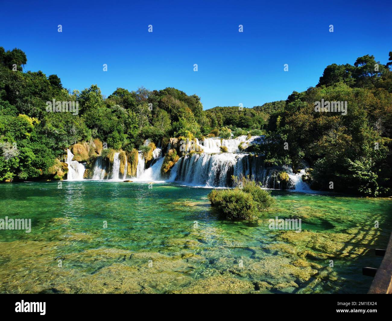 The beautiful waterfalls surrounded by green vegetation in Krka ...