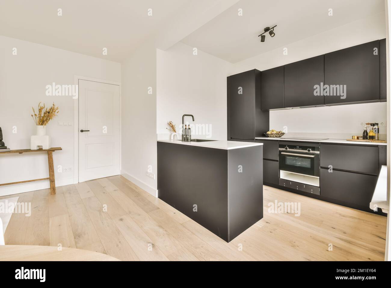 a modern kitchen with black cabinets and white countertops on the ...