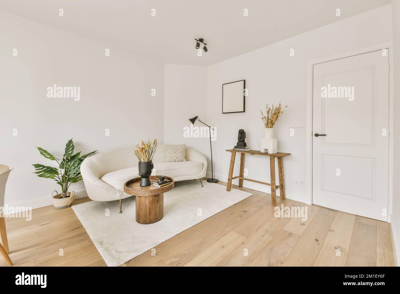 a living room with white walls and hardwood flooring the room is ...