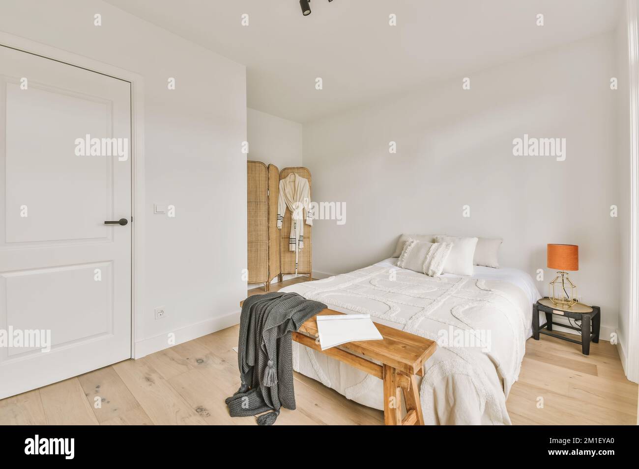 a bedroom with white walls and hardwood flooring the room has a bed ...