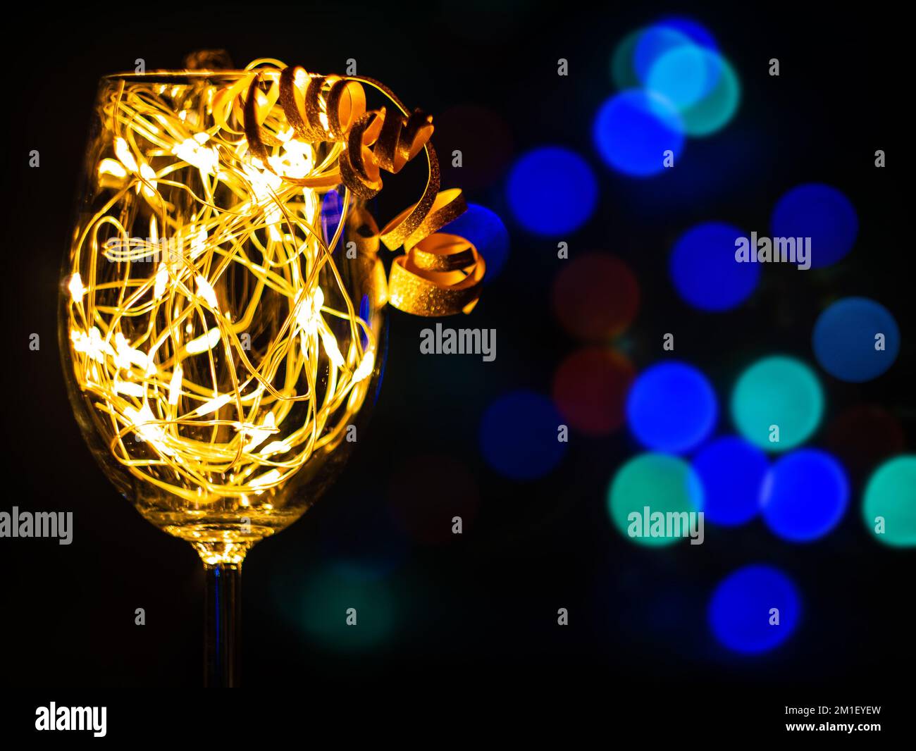 Crystal wine glasses with golden glowing garland on Christmas table ...