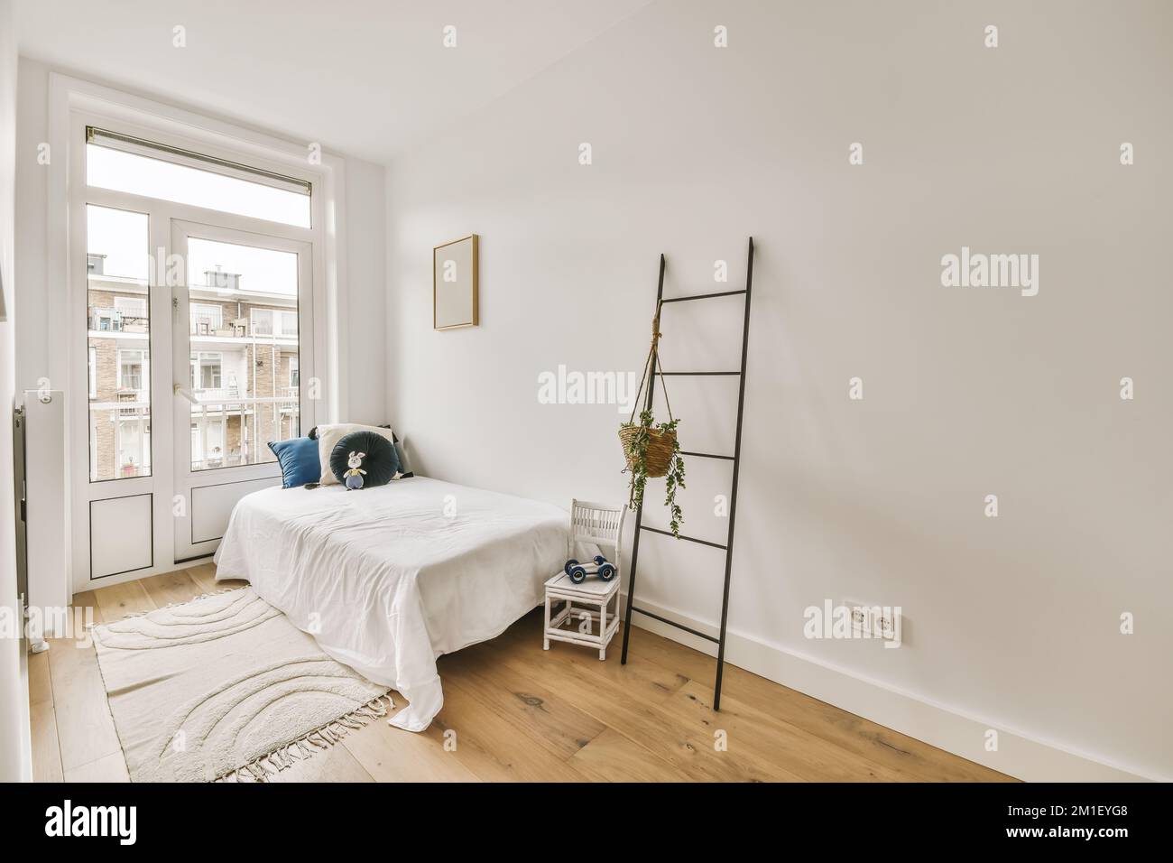 a bedroom with white walls and hardwood flooring in the room, there is ...