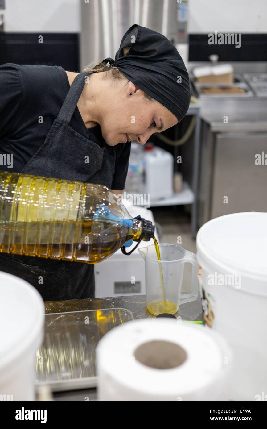 female chef measuring olive oil in professional kitchen Stock Photo - Alamy