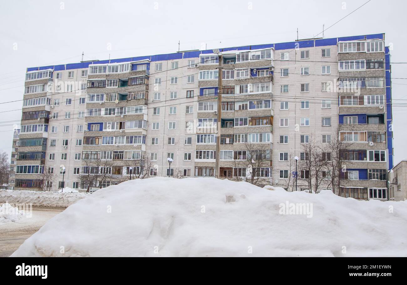 A large snowdrift in the background of a street with a multi-storey ...